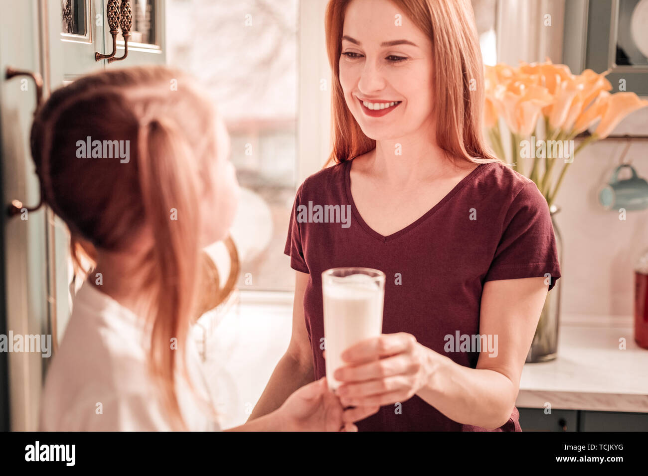 Positive delighted young mommy giving milk to her kid Stock Photo - Alamy