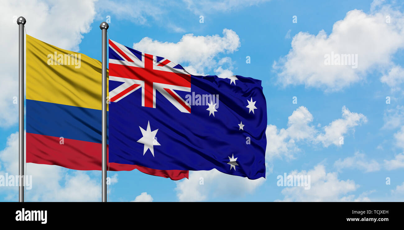 Colombia and Australia flag waving in the wind against white cloudy ...