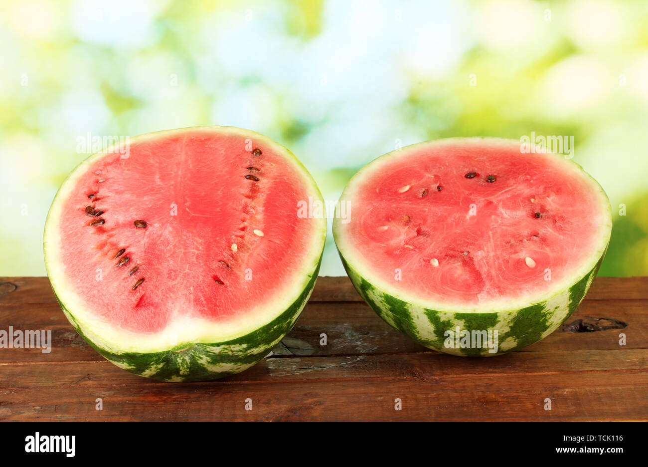 Halves of juicy watermelon on green background close-up Stock Photo - Alamy