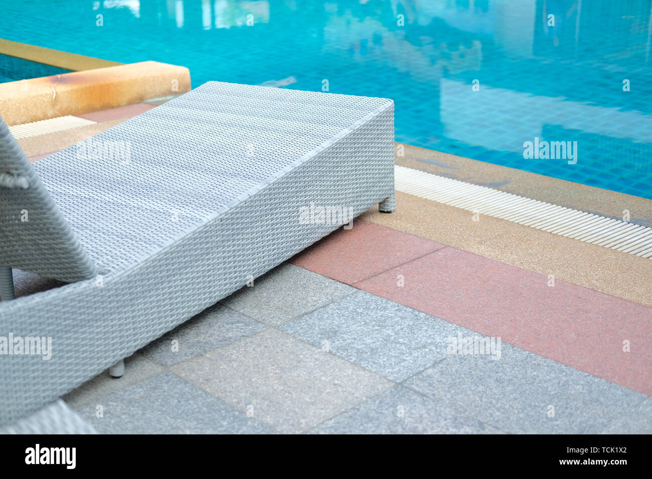 wicker rattan pool sun bed deckchair at poolside of swimming pool ...