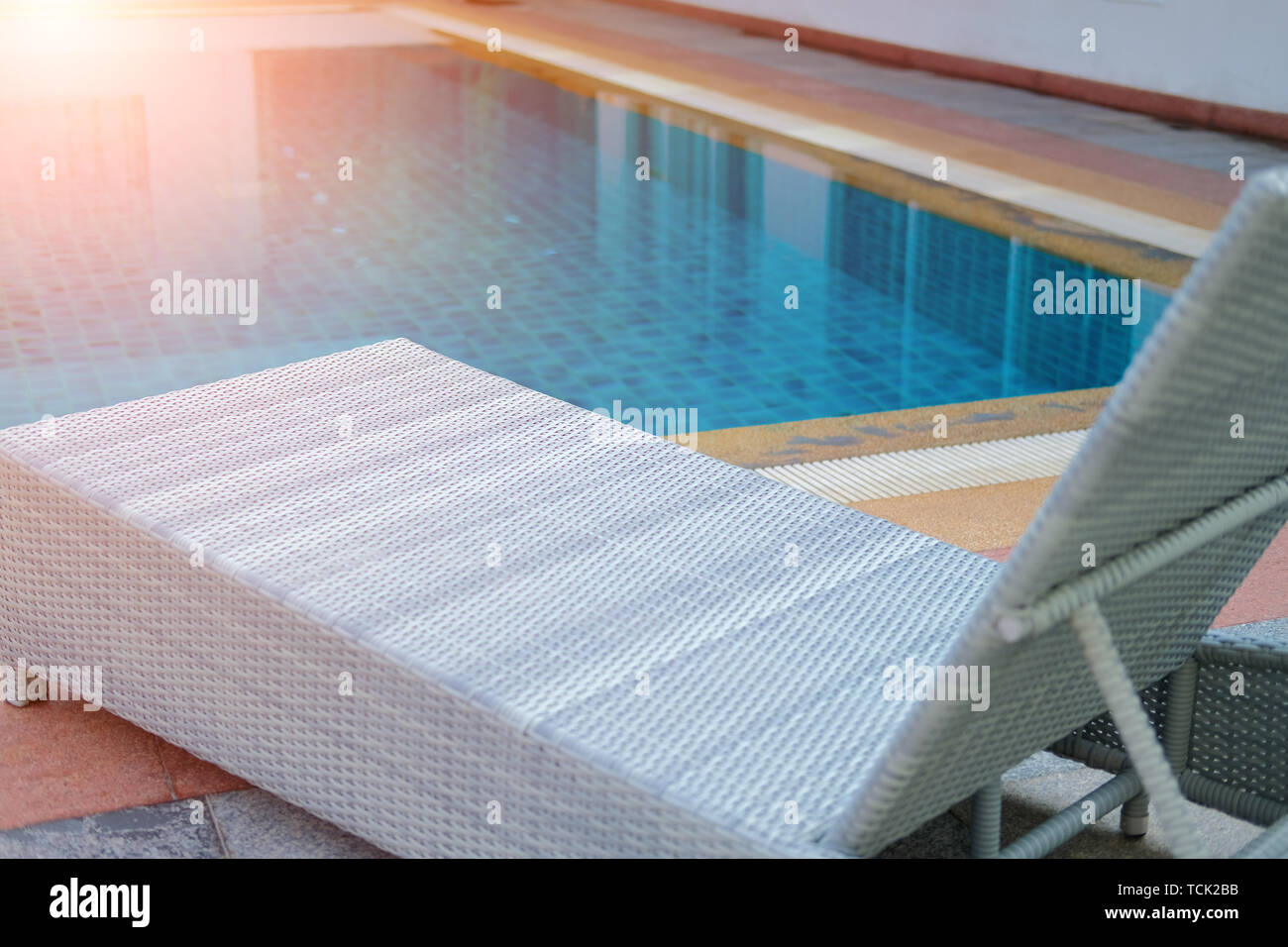 wicker rattan pool sun bed deckchair at poolside of swimming pool ...
