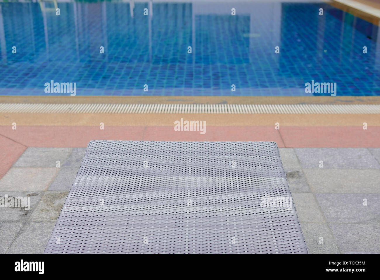 wicker rattan pool sun bed deckchair at poolside of swimming pool ...