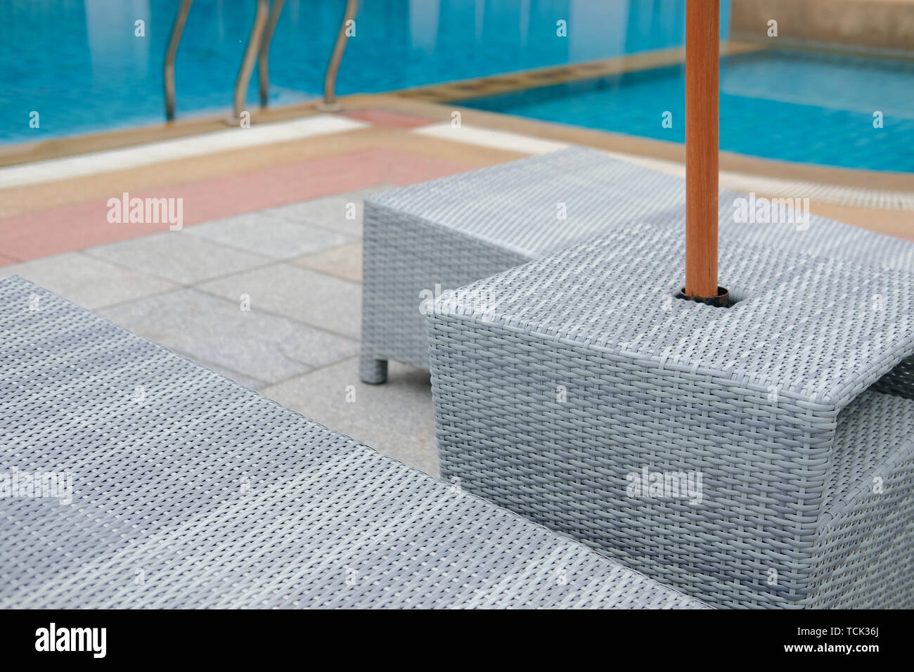 wicker rattan pool sun bed deckchair at poolside of swimming pool ...