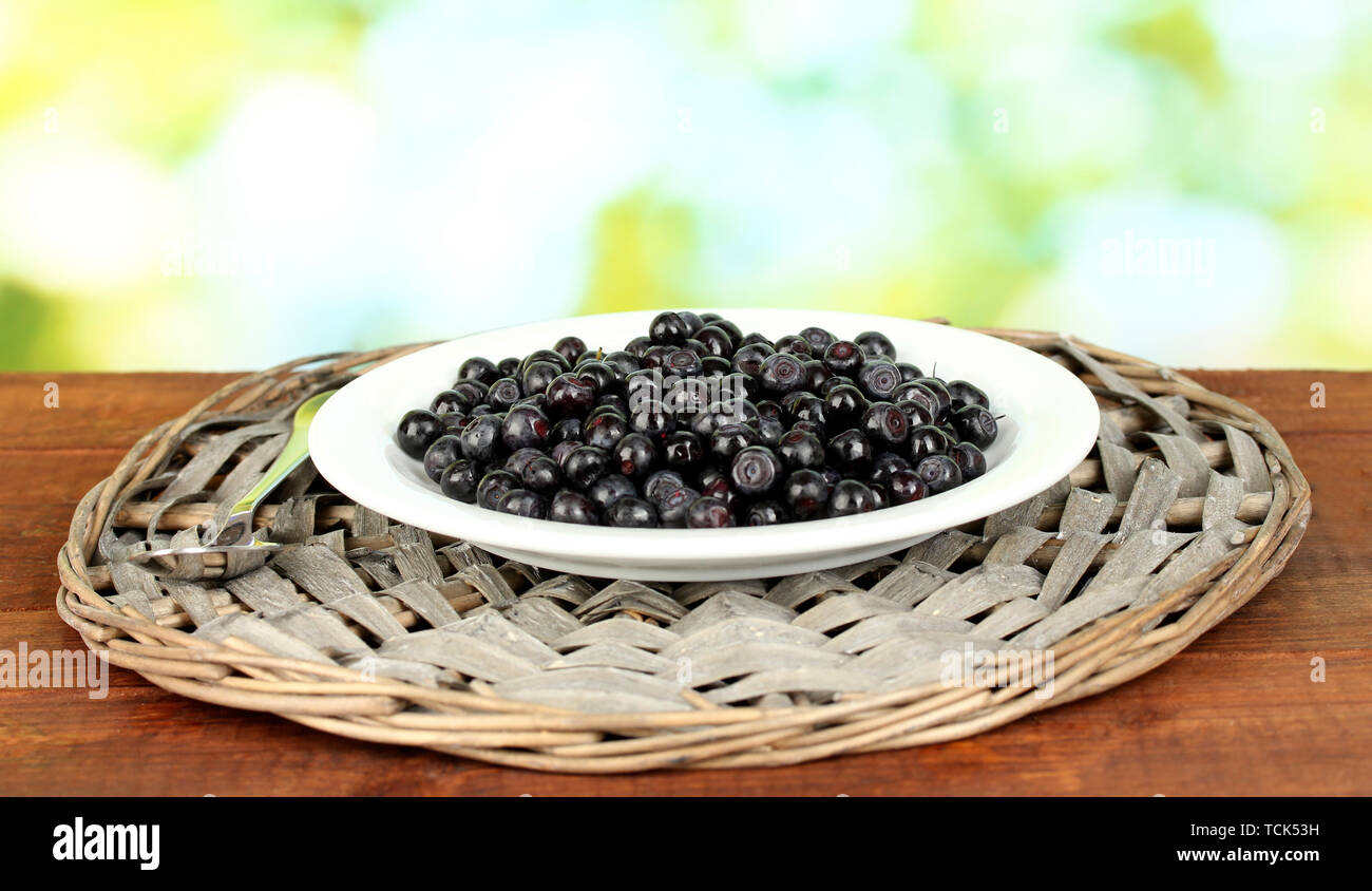 Fresh blueberries in plate on green background Stock Photo - Alamy