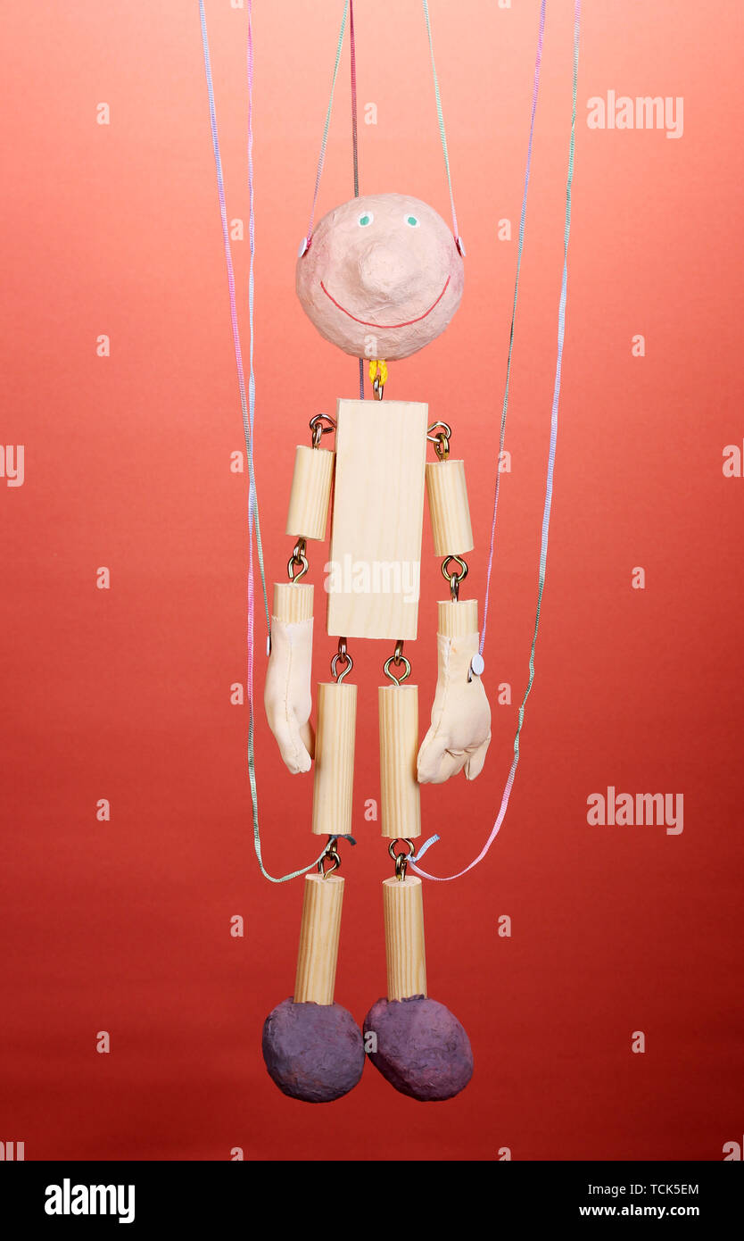 Wooden puppet on red background Stock Photo - Alamy