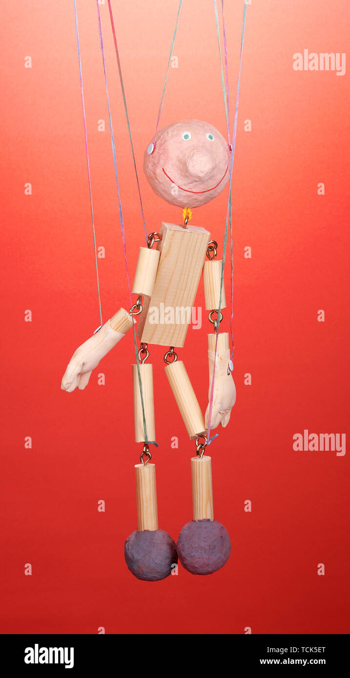 Wooden puppet on red background Stock Photo - Alamy