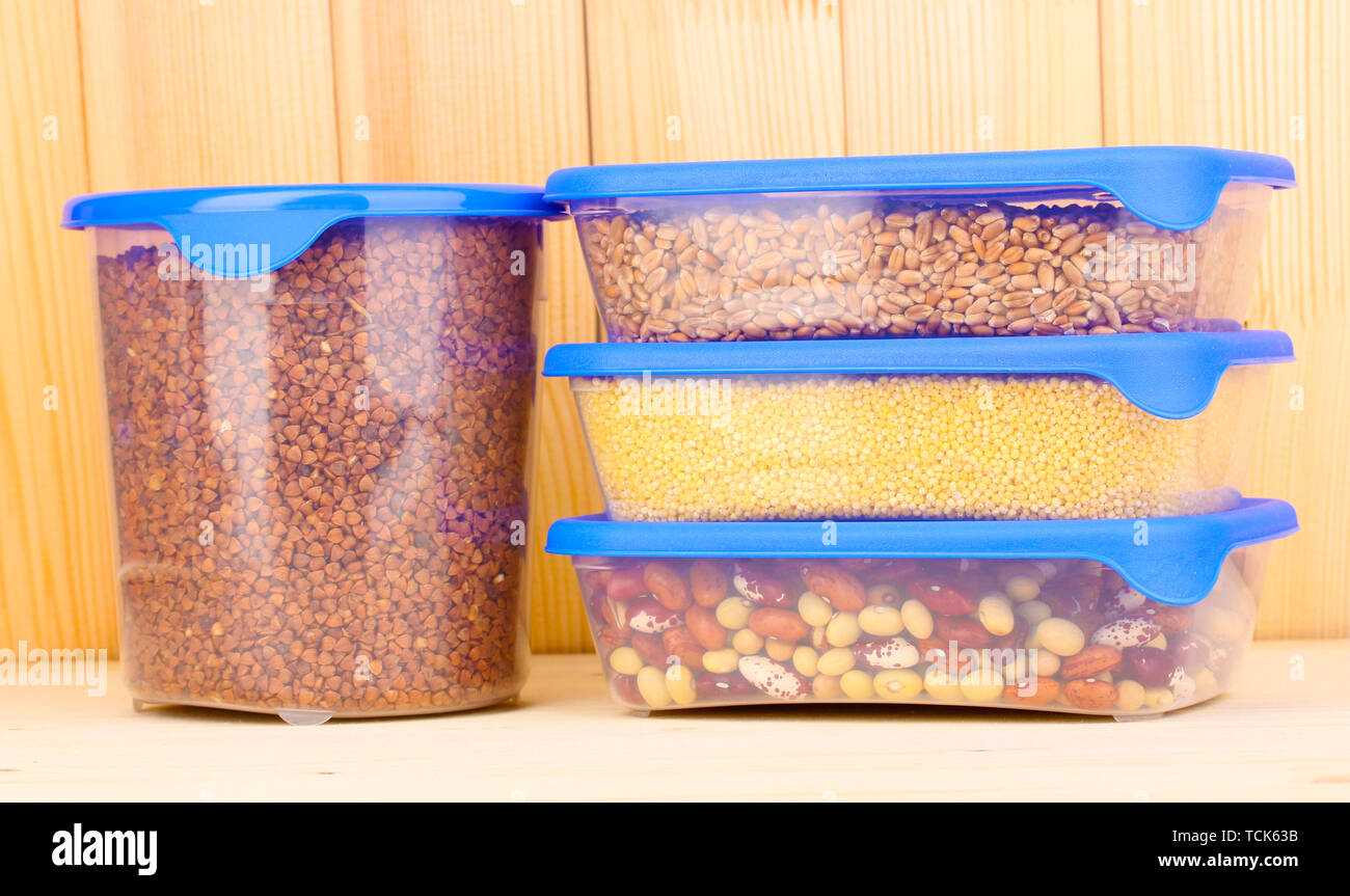 Filled plastic containers on wooden background Stock Photo - Alamy
