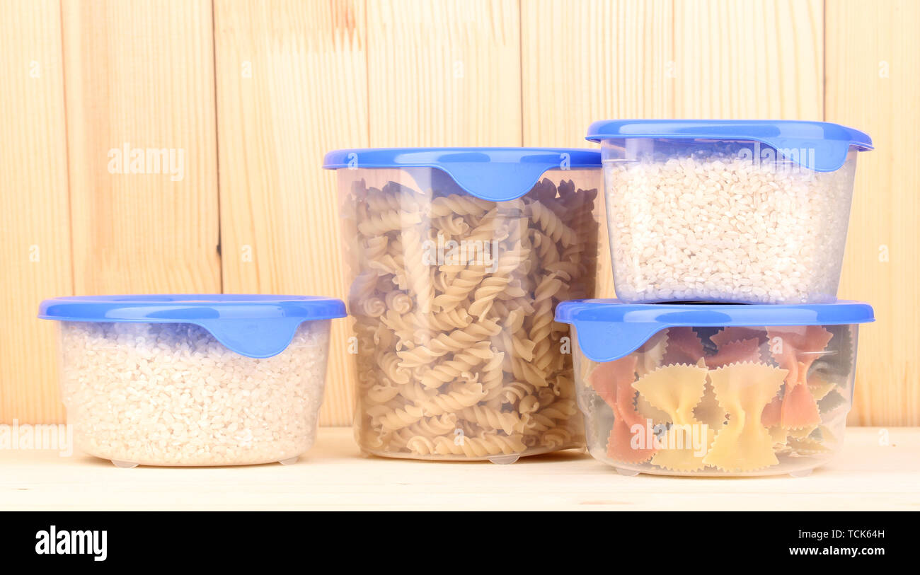 Filled plastic containers on wooden background Stock Photo - Alamy