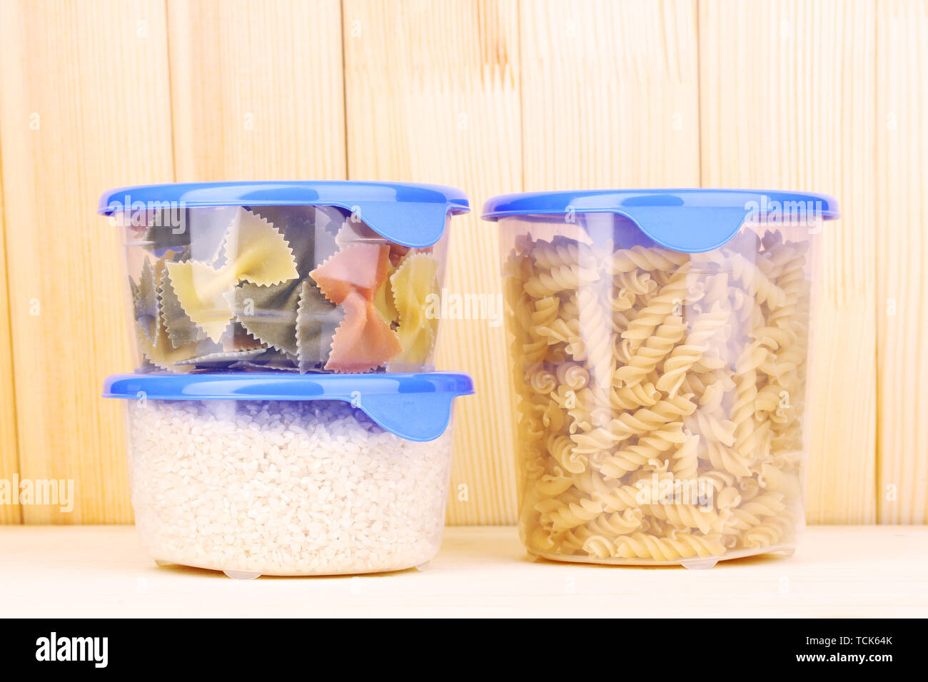 Filled plastic containers on wooden background Stock Photo - Alamy