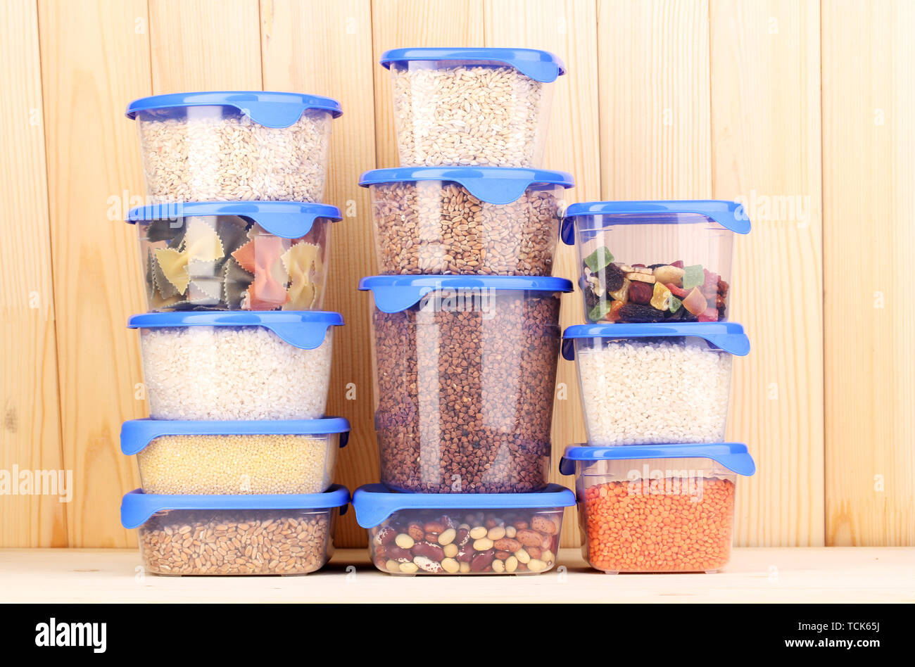 Filled plastic containers on wooden background Stock Photo - Alamy