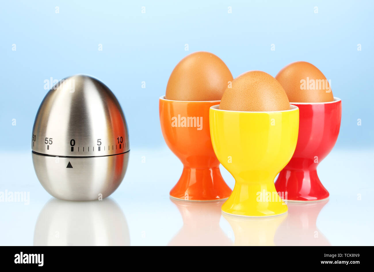 egg timer and egg in color stand on blue background Stock Photo - Alamy