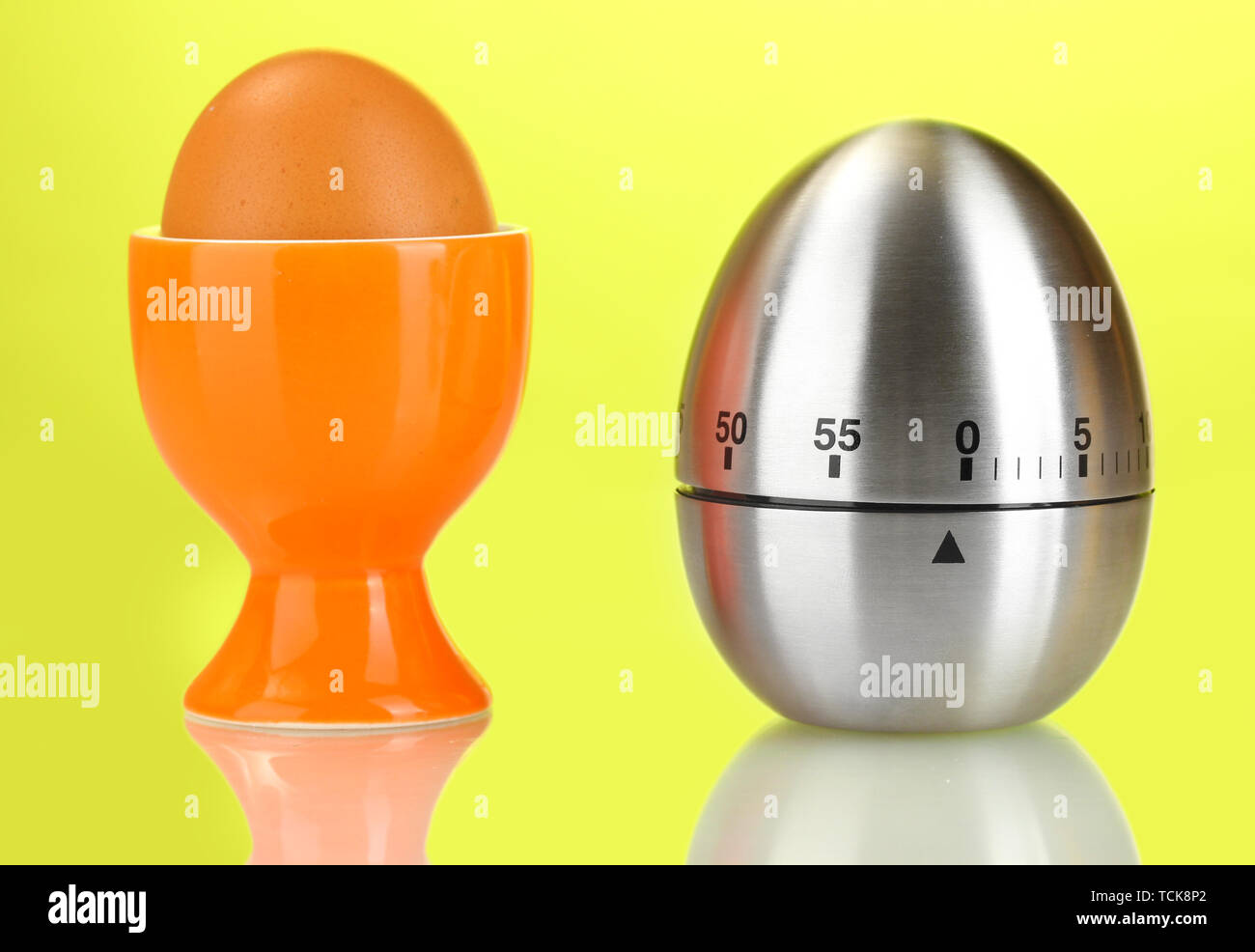 egg timer and egg in orange stand on blue background Stock Photo - Alamy