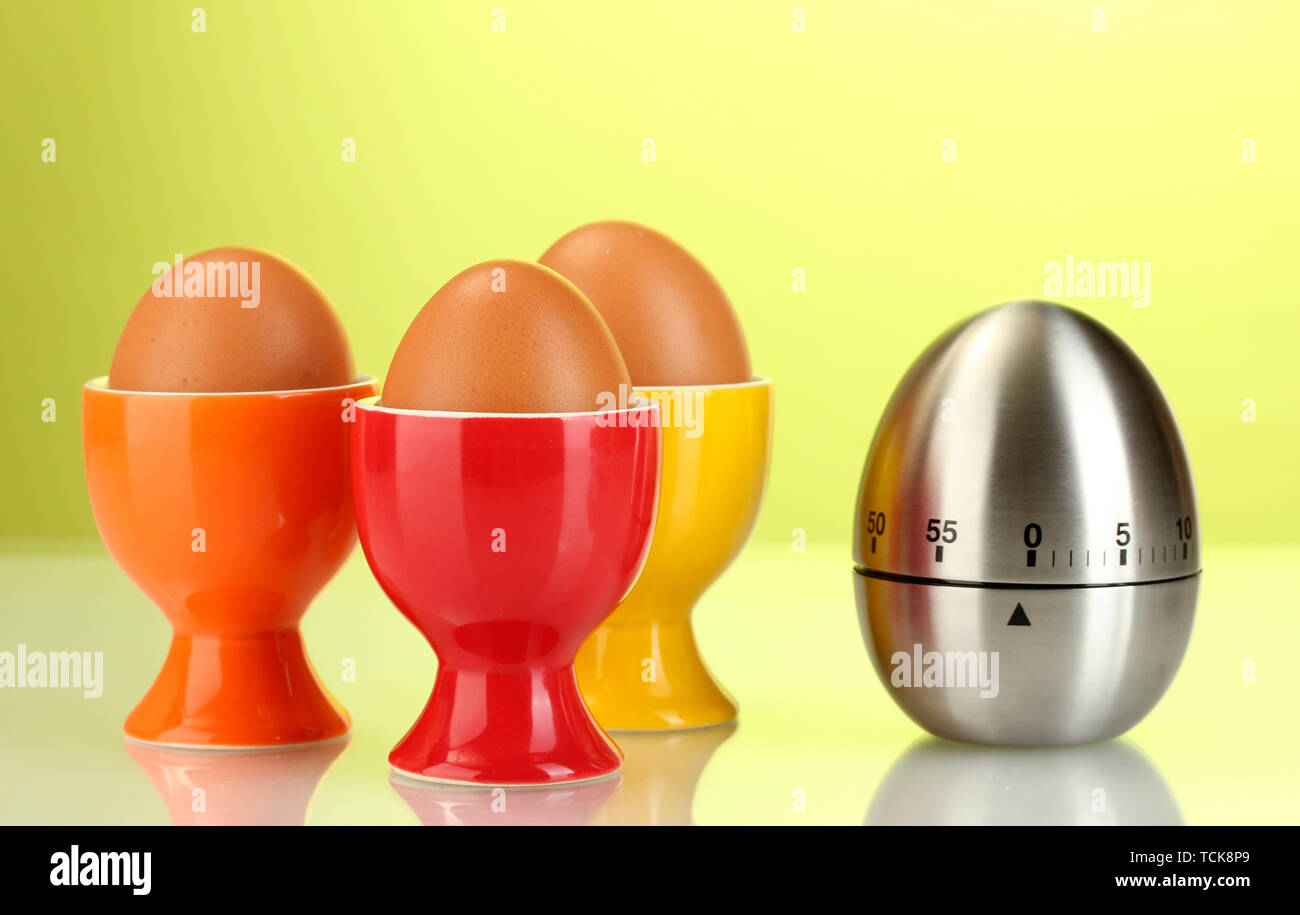 egg timer and egg in color stand on green background Stock Photo - Alamy
