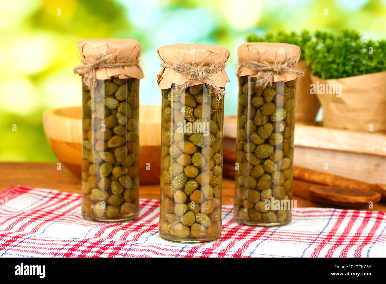 Glass jars with tinned capers on green background Stock Photo - Alamy