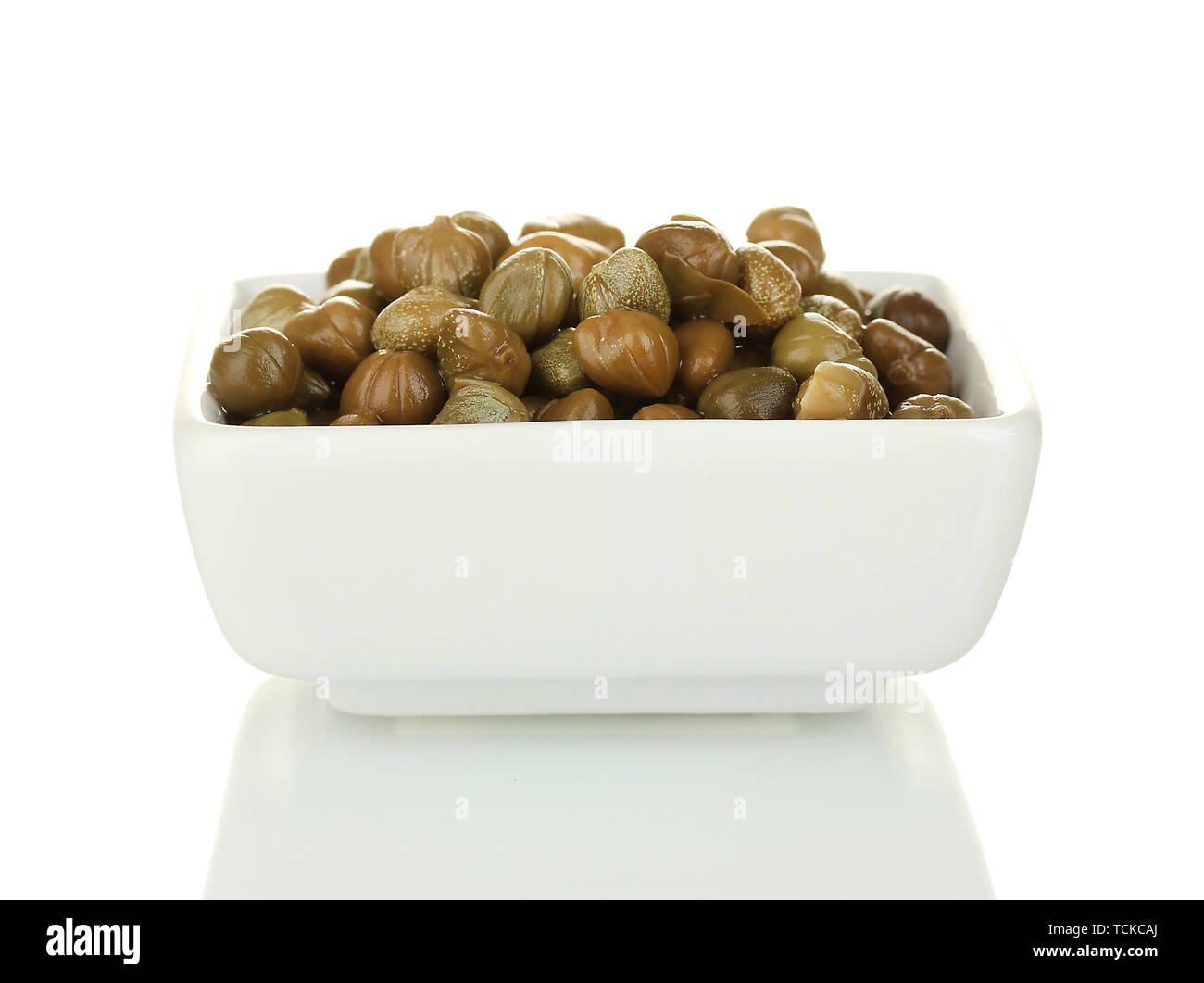 green capers in white bowl isolated on white background Stock Photo - Alamy