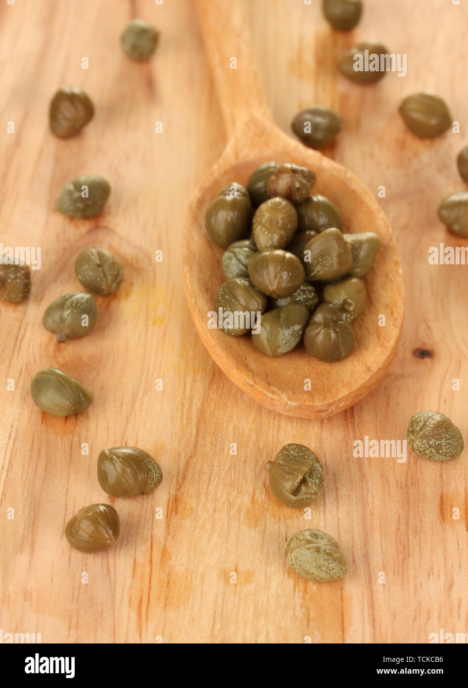green capers in wooden spoon on wooden background close-up Stock Photo ...