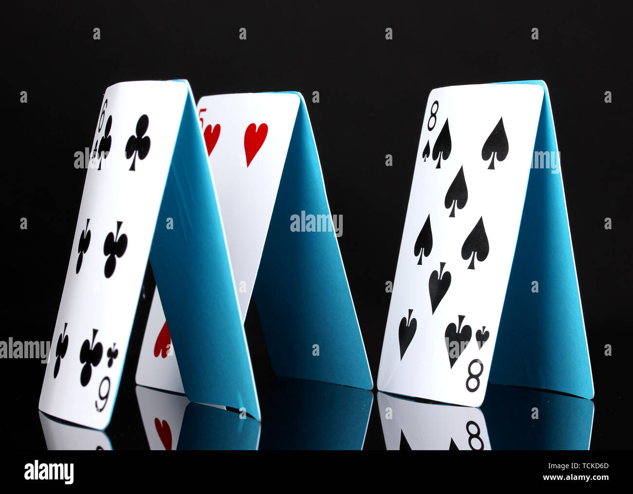 Card house isolated on black Stock Photo - Alamy