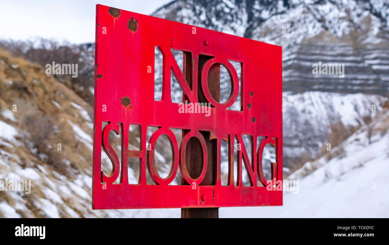 Panorama frame Close up of a weathered red No Shooting sign on a rusty ...