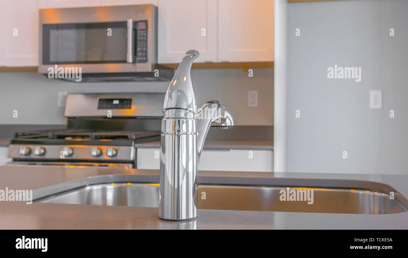 Panorama Modern kitchen interior with close up on the shiny faucet and ...