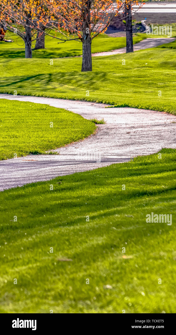 Panorama Grassy terrain with a curving pathway that leads to the road ...