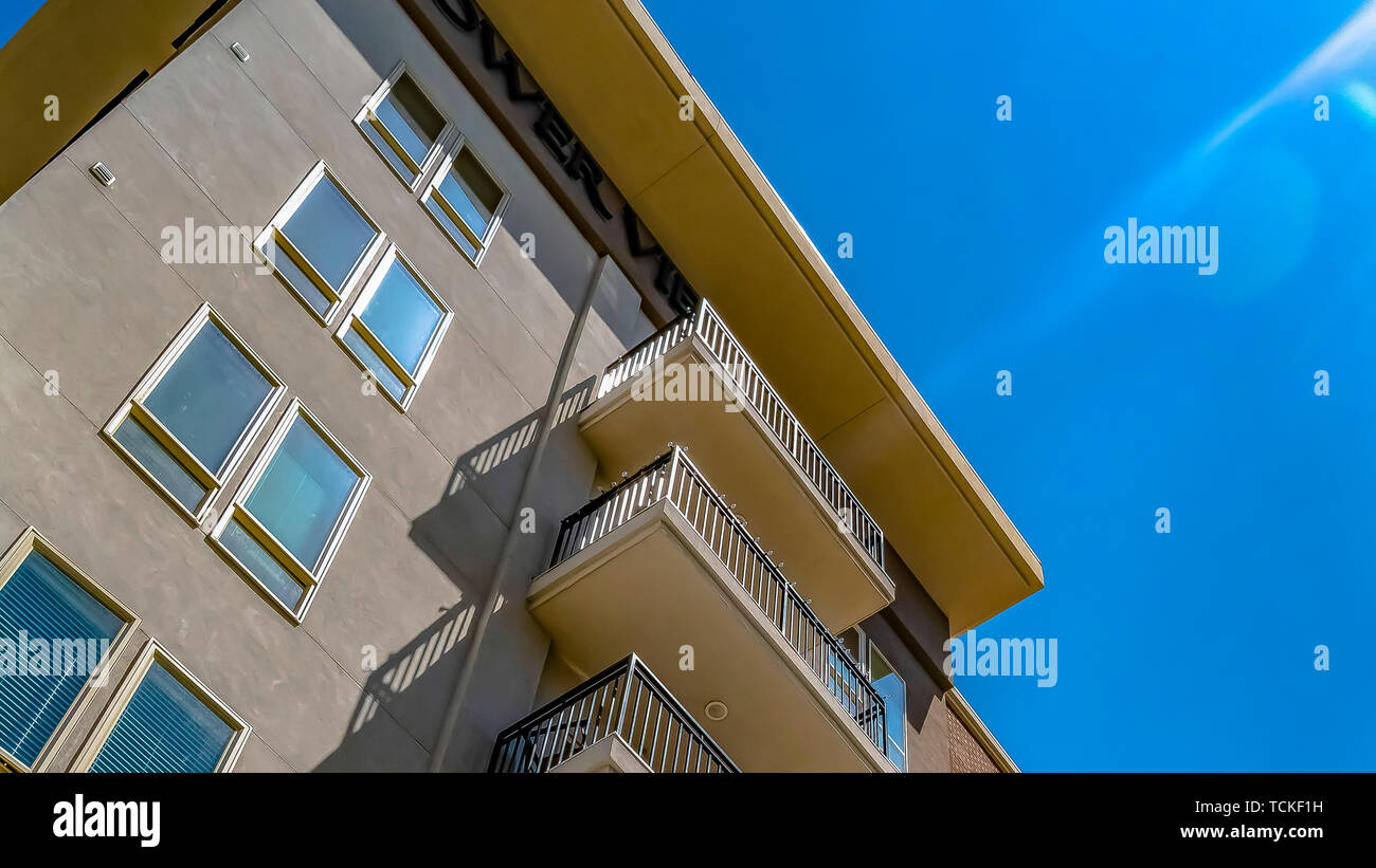 Panorama View from below of a building with small balconies on a sunny ...