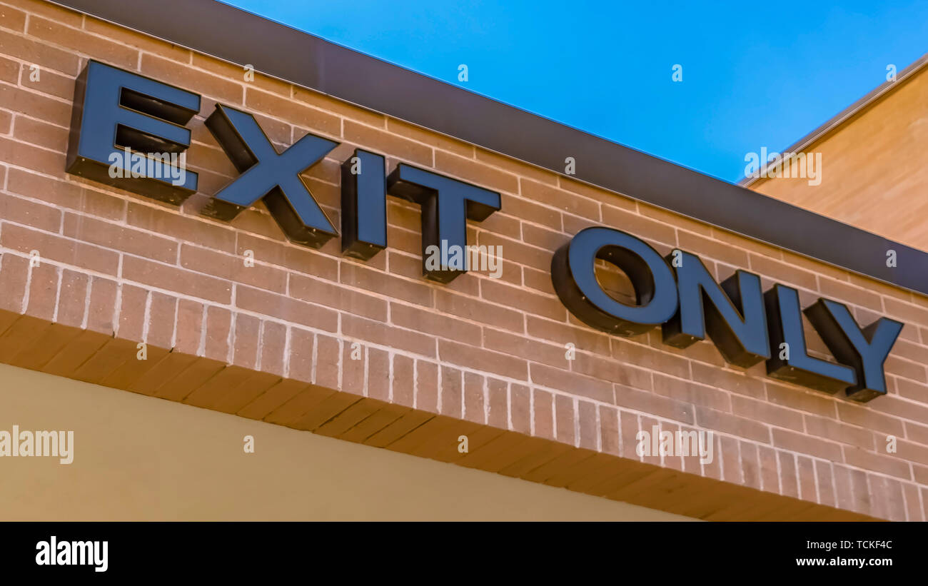 Panorama frame Exit only sign on the exterior brick wall of a building ...