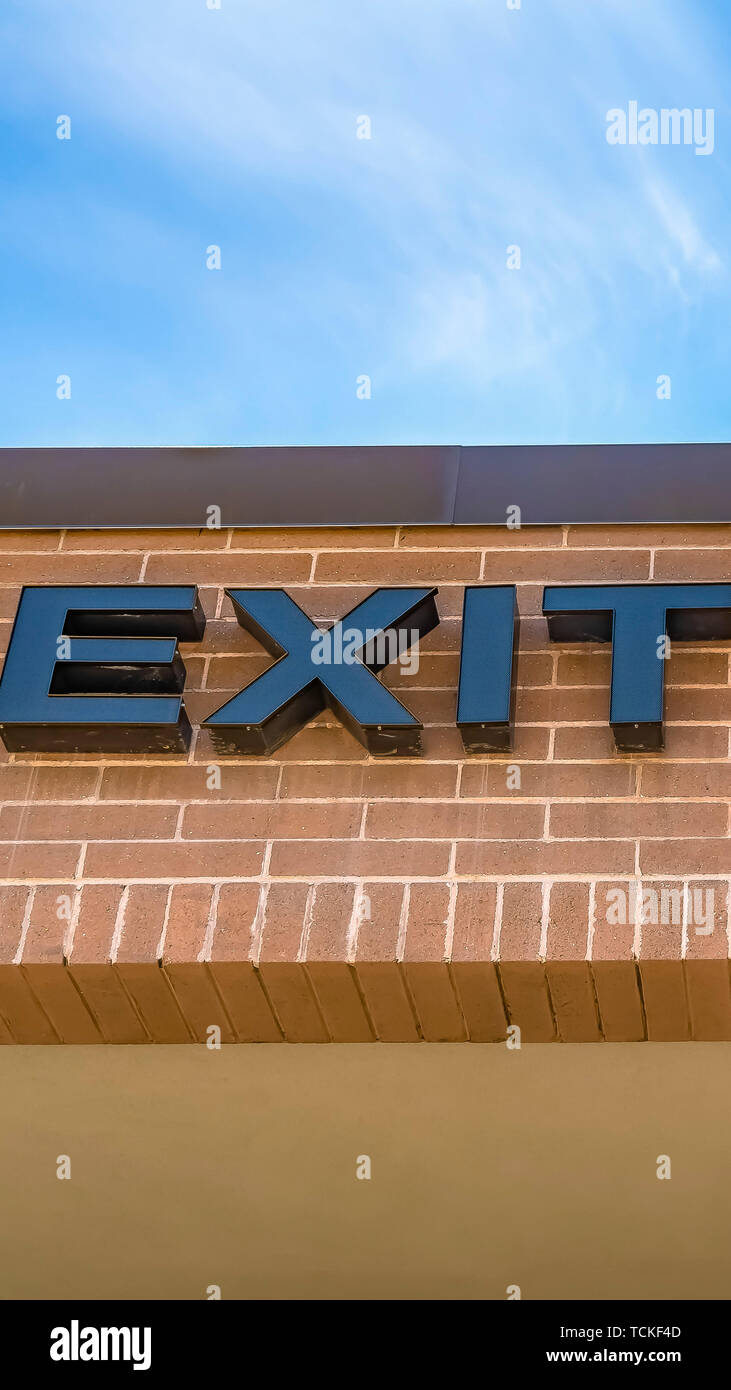 Panorama Close up of Exit Only sign on the exterior red brick wall of a ...