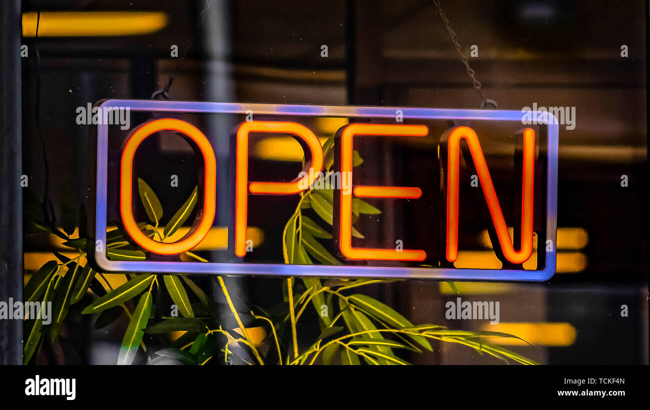 Panorama frame Close up of a neon open sign hanging on the glass wall ...