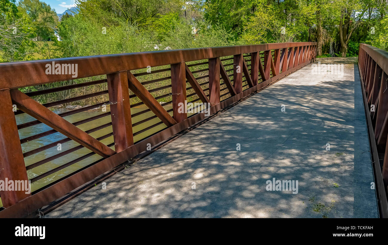 Panorama Bridge with brown guardrails overlooking a river and abundant ...