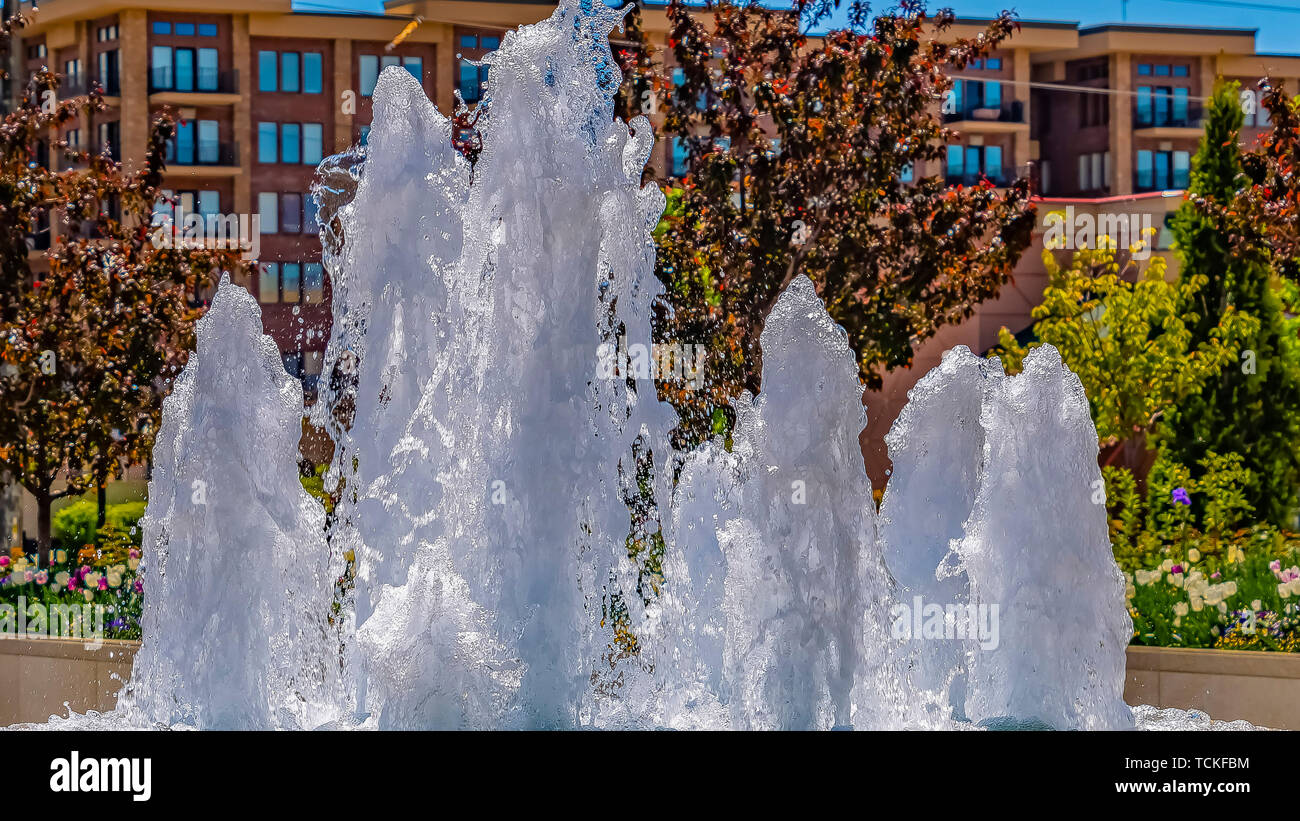 Panorama Fountain with sparkling water surging upwards against flowers ...