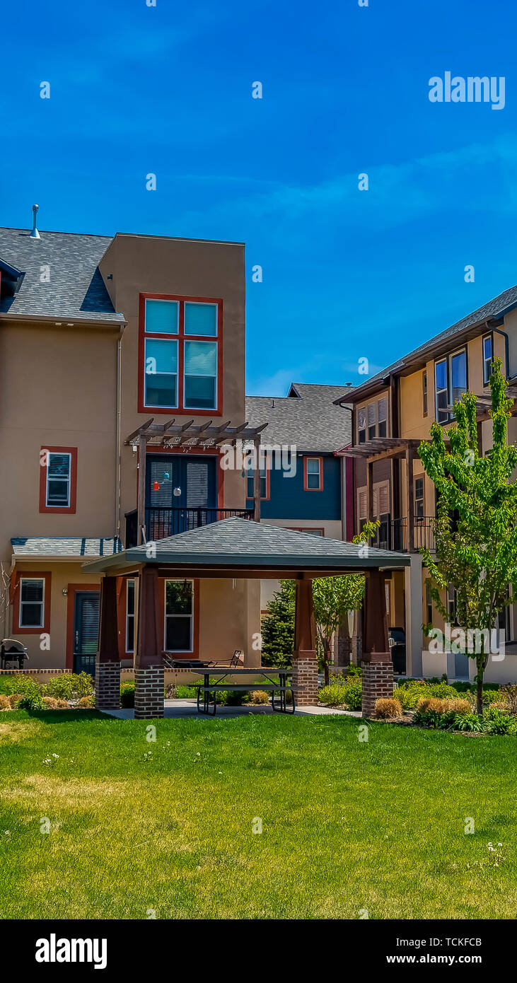 Panorama Patio on a lawn surrounded by townhouses with bright blue sky ...