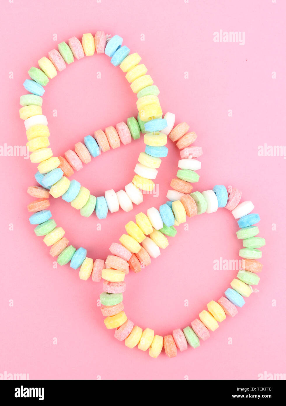 Color candies on rope on pink background Stock Photo - Alamy