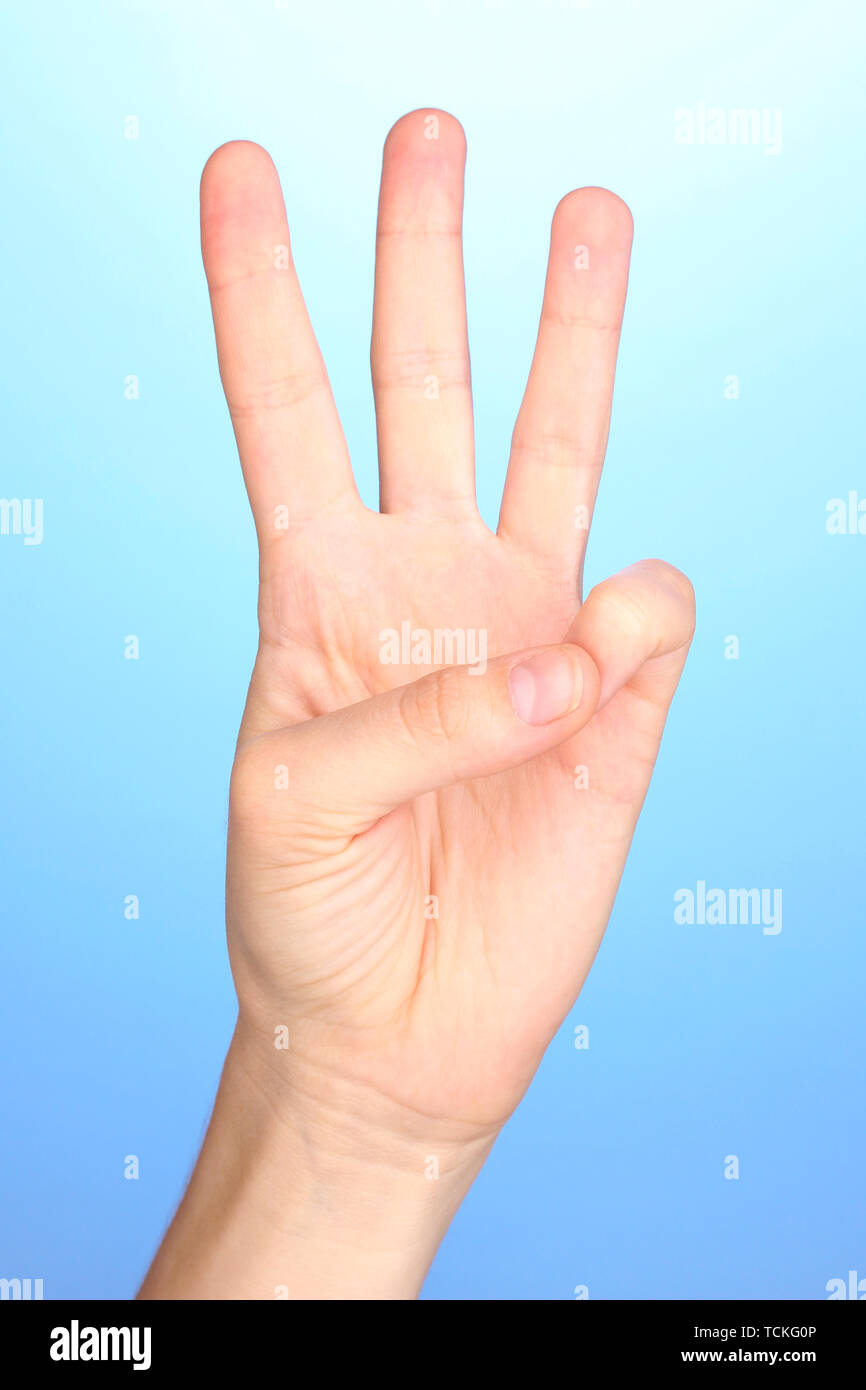 Hand making sign on blue background Stock Photo - Alamy