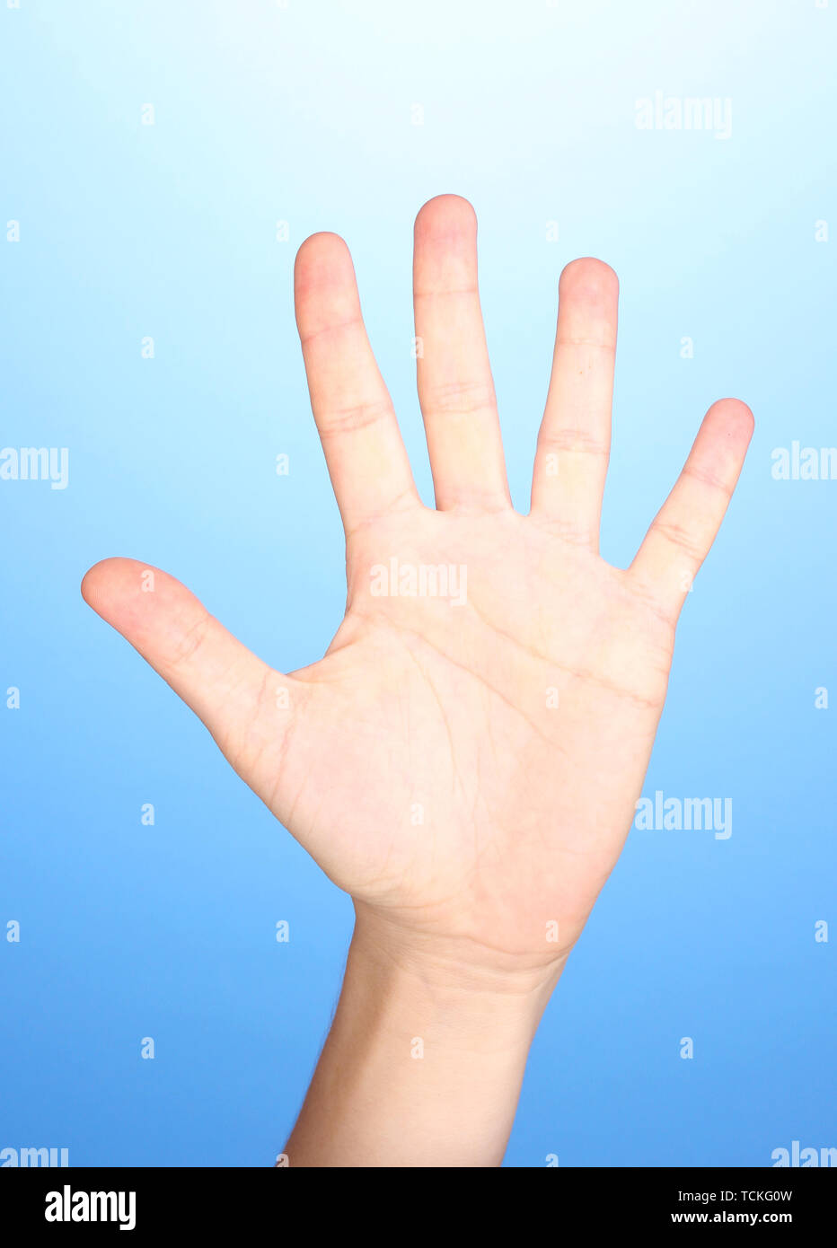 Hand making sign on blue background Stock Photo - Alamy