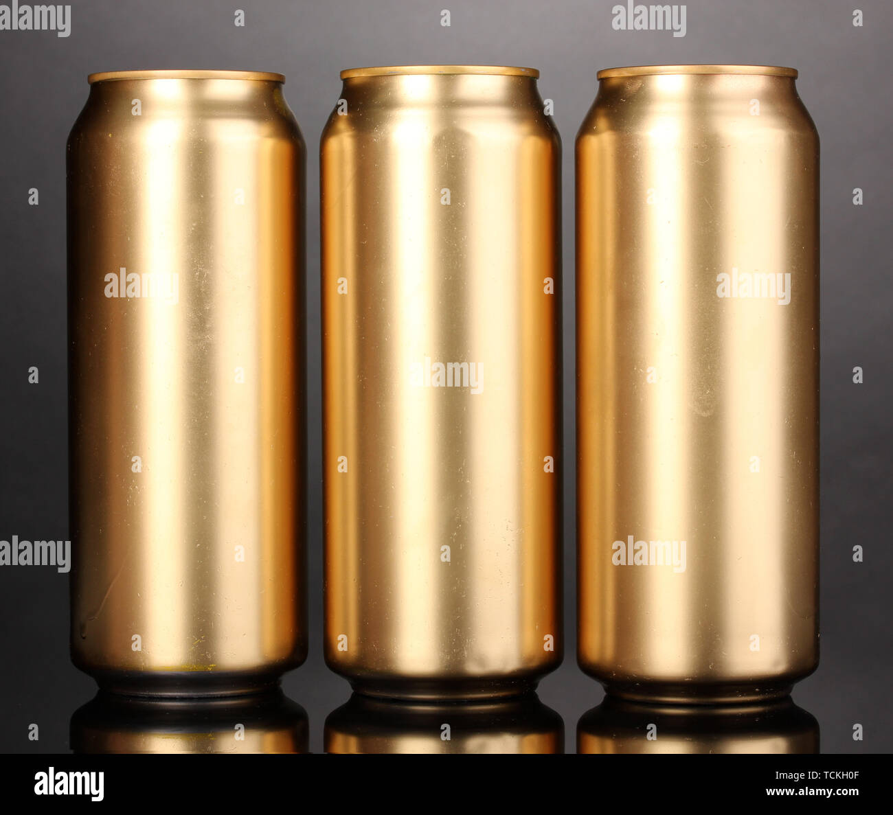 golden cans on grey background Stock Photo - Alamy