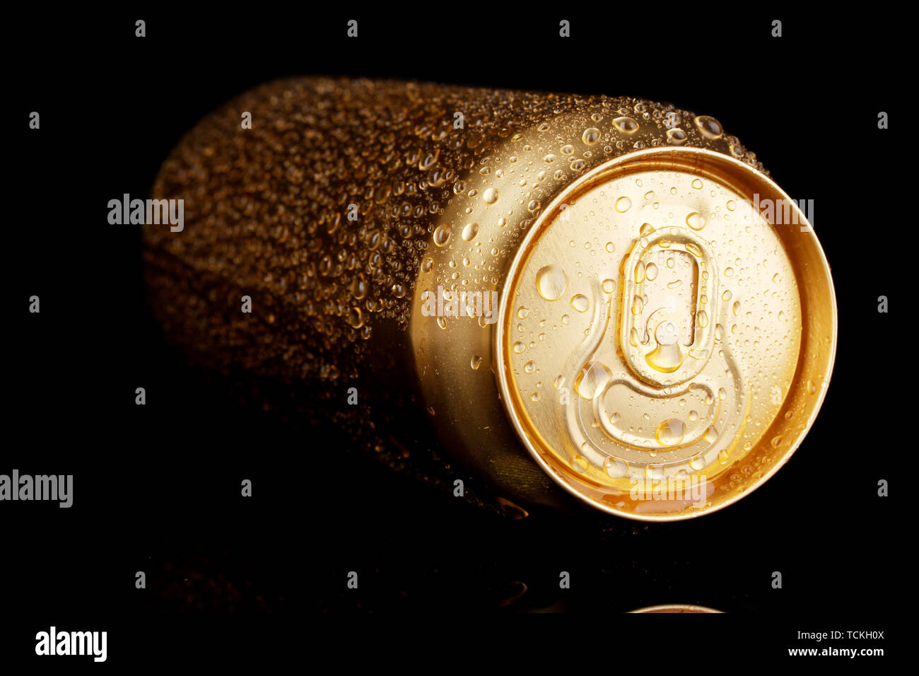 golden can with water drops isolated on black Stock Photo - Alamy