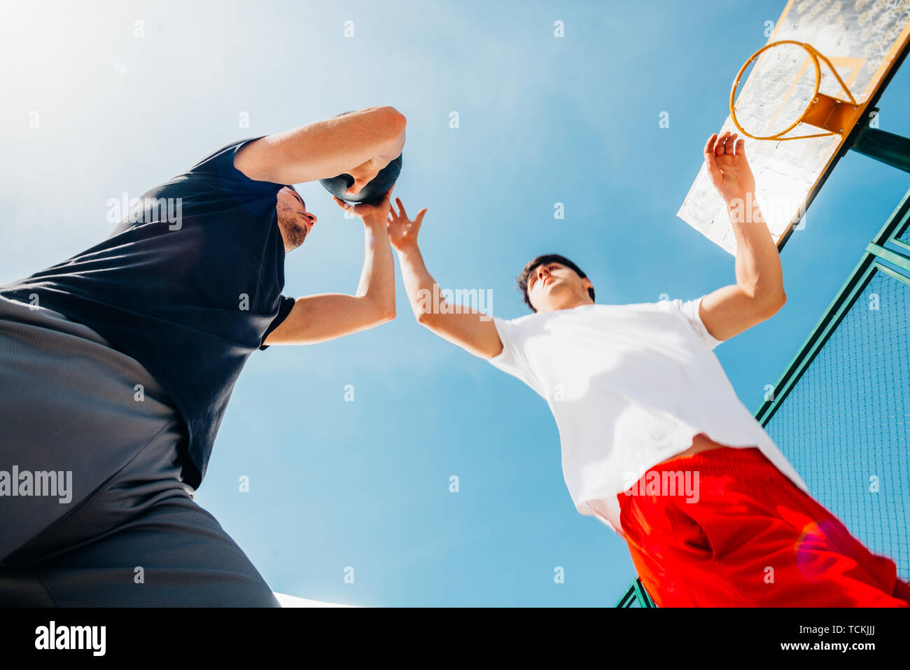 Two caucasian basketball player fighting for ball possession at the ...