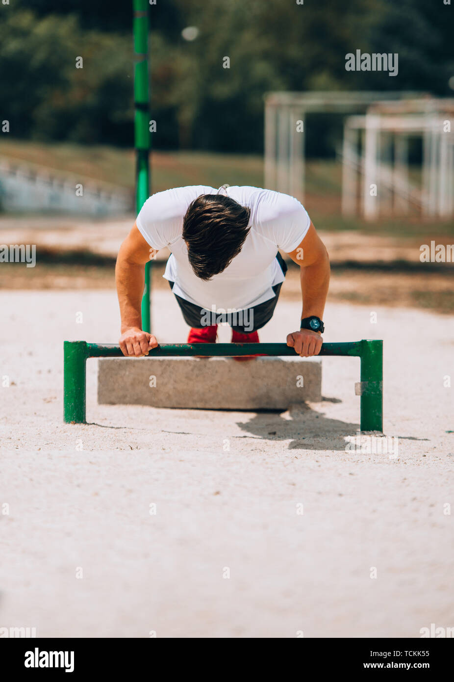 Strong, handsome man doing push-ups in a gym as bodybuilding exercise ...