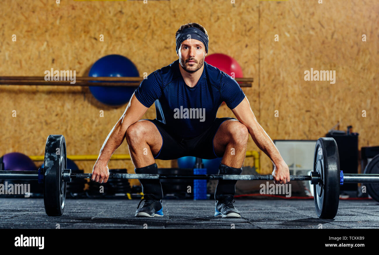 Fitness man is raising barbell in the gym Stock Photo - Alamy