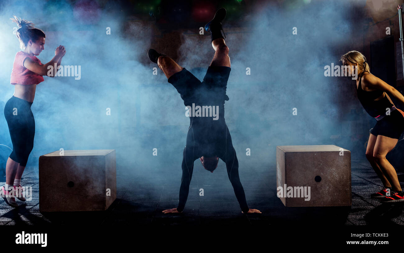 Crossfit class jumping on wooden boxes guided by trainer Stock Photo ...