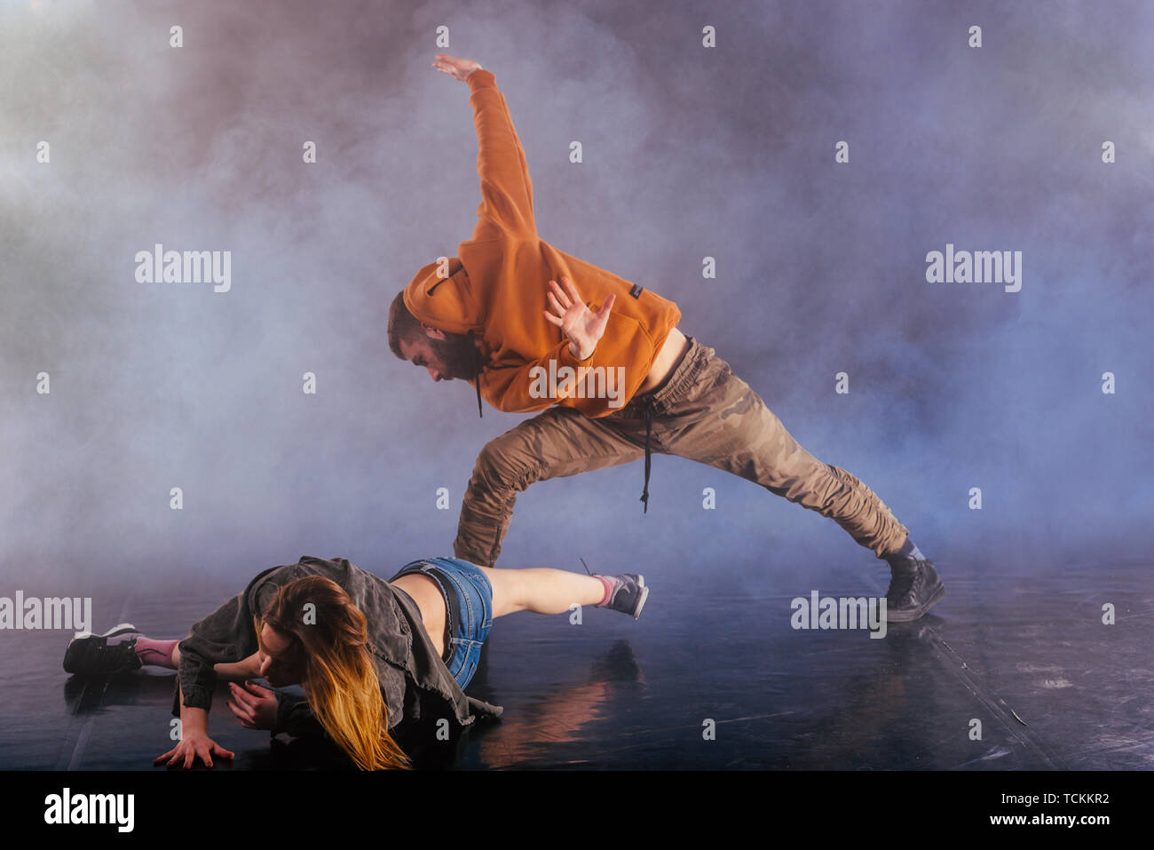 The beautiful female dancer is laying on the floor while her male ...