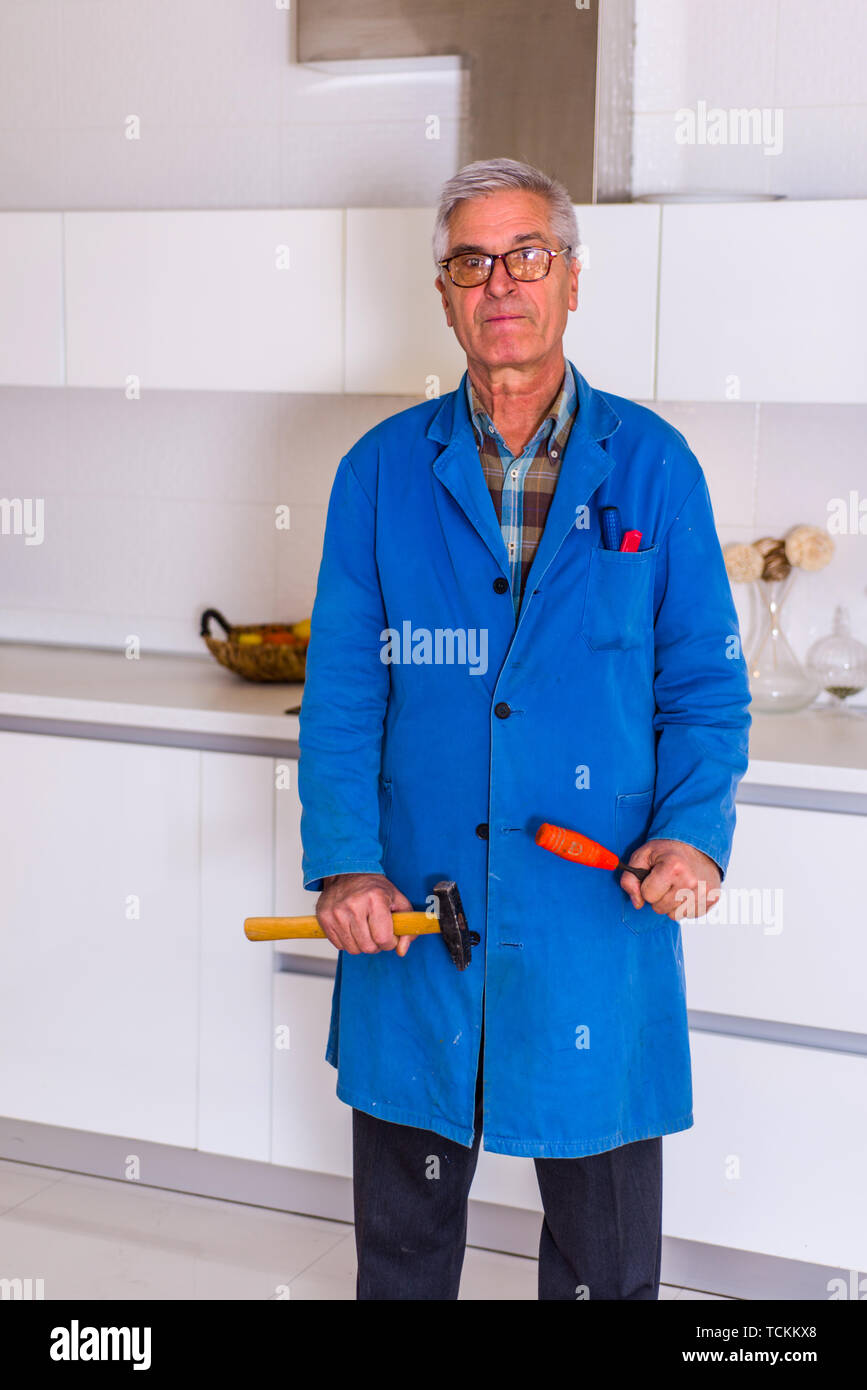Workman standing in white kitchen with his tools and working with his ...