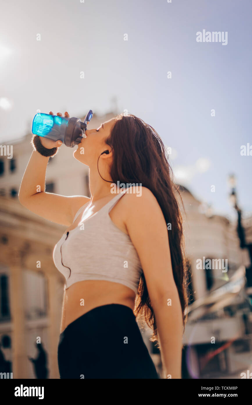 Fitness and healthy lifestyle concept with female model while drink ...