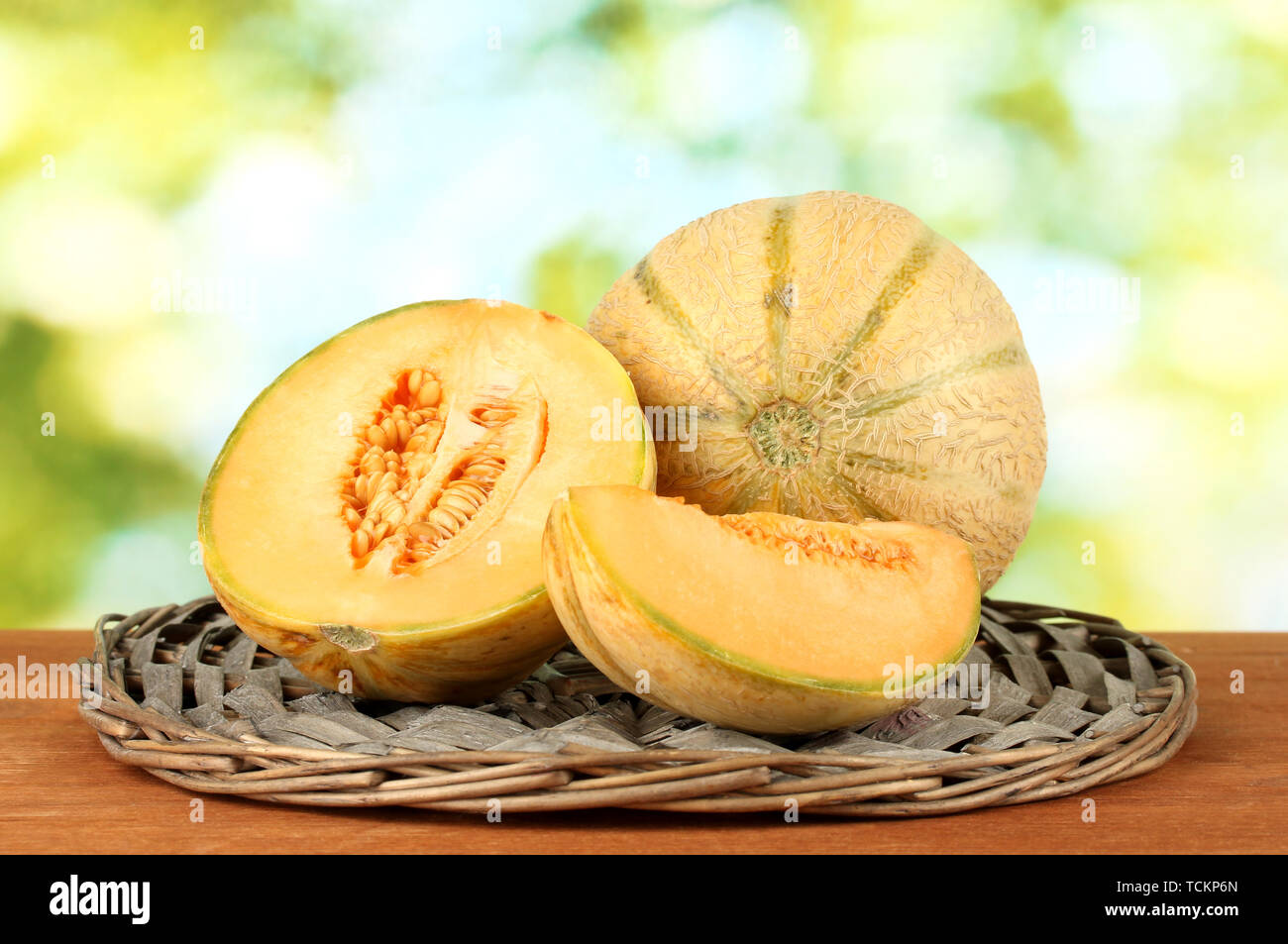 cut melon on wicker mat on green background close-up Stock Photo - Alamy