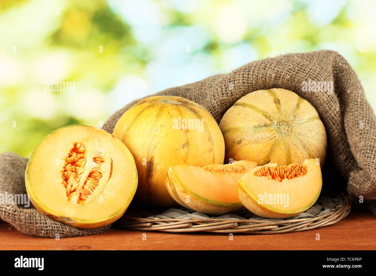 cut melon on wicker mat on green background close-up Stock Photo - Alamy