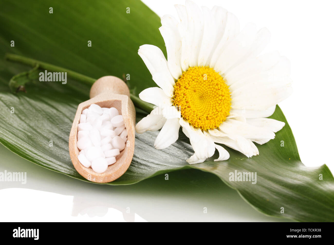 homeopathic tablets and flower on green leaf isolated on white Stock ...
