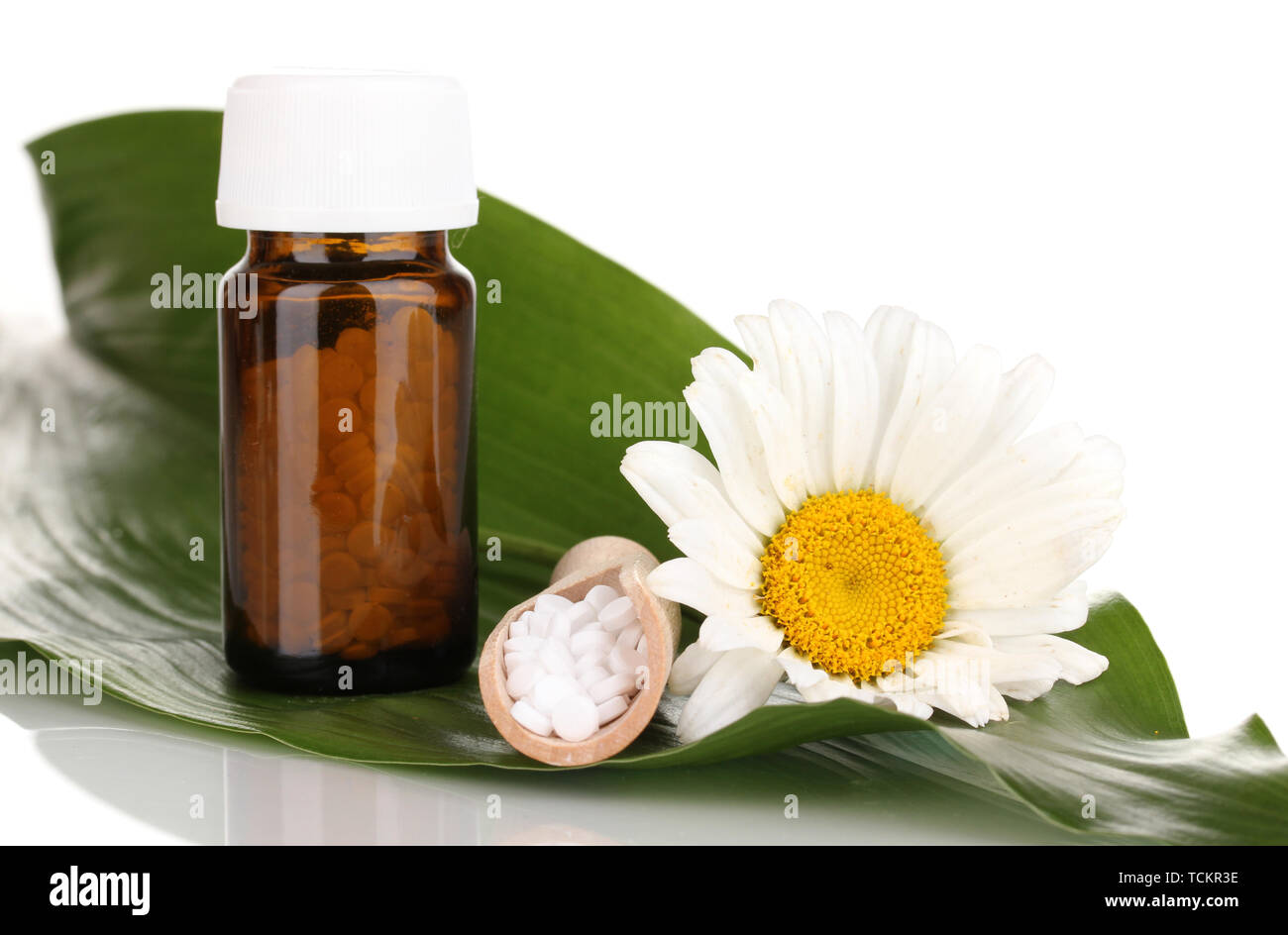 homeopathic tablets and flower on green leaf isolated on white Stock ...