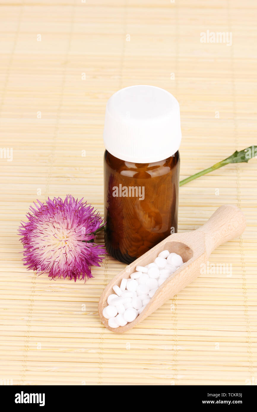 medicine bottle with tablets and flower on bamboo mat Stock Photo - Alamy