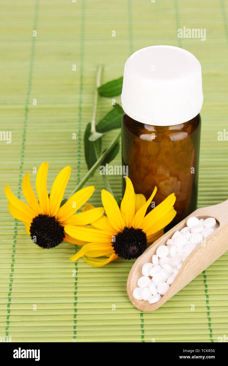 medicine bottle with tablets and flowers on bamboo mat Stock Photo - Alamy