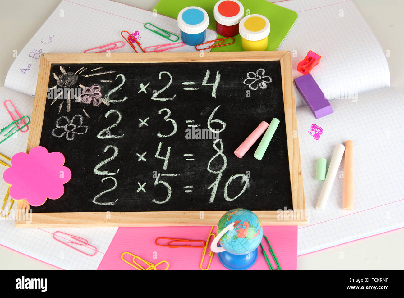 Small school desk with various school supplies close-up isolated on ...